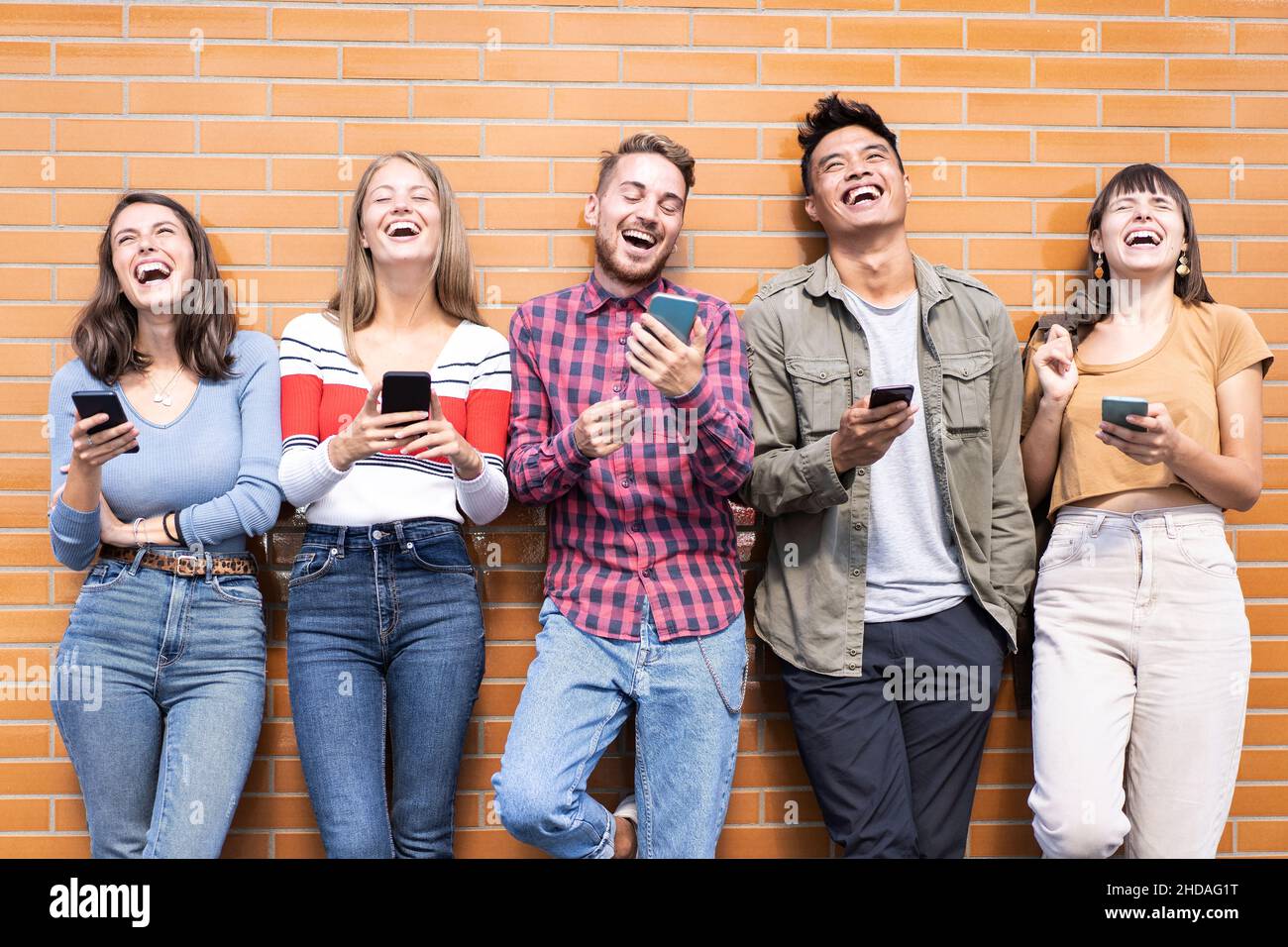Group of happy friends having fun with mobile smartphones outdoors ...