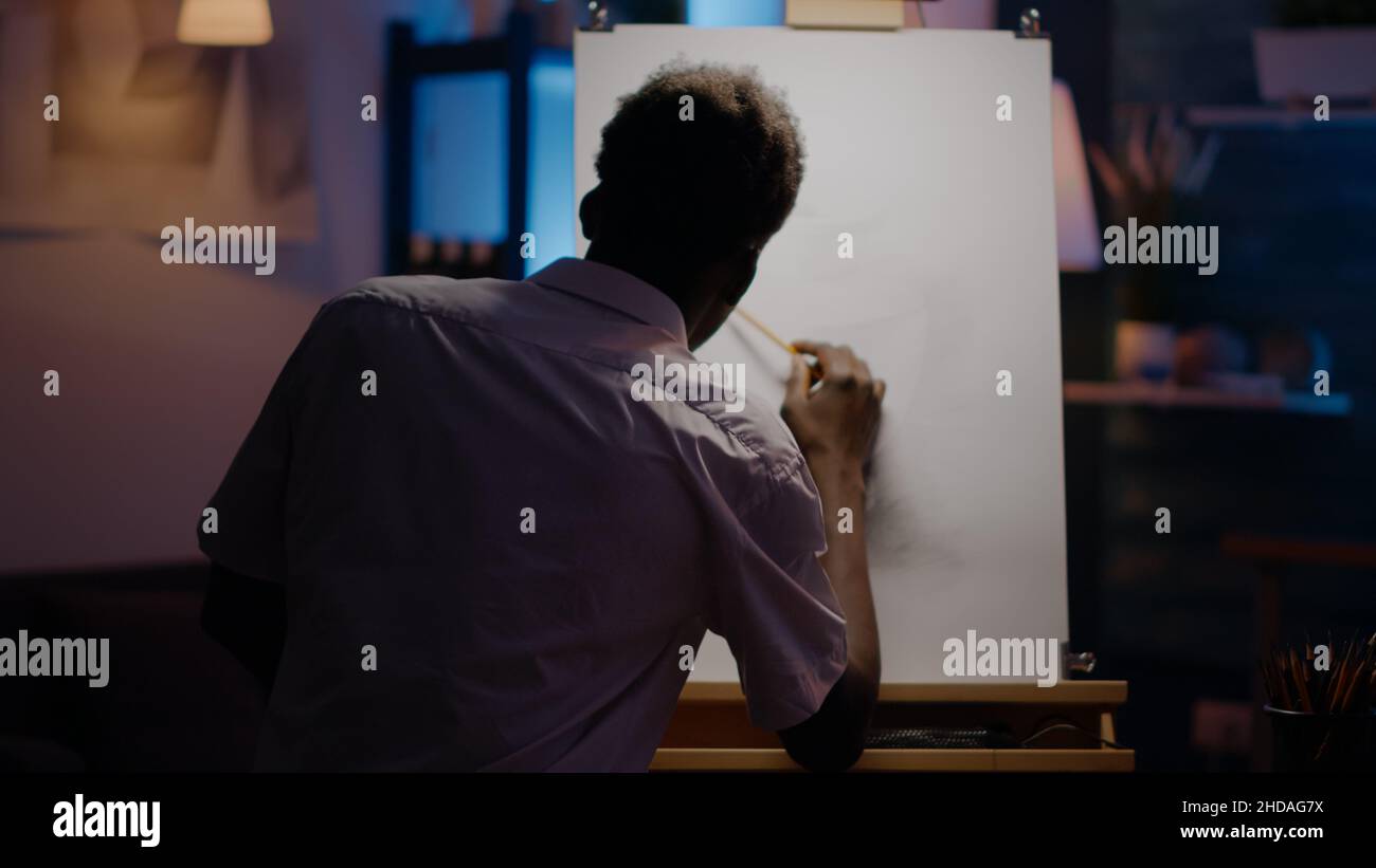 African american artist drawing vase on canvas with pencil in artwork ...