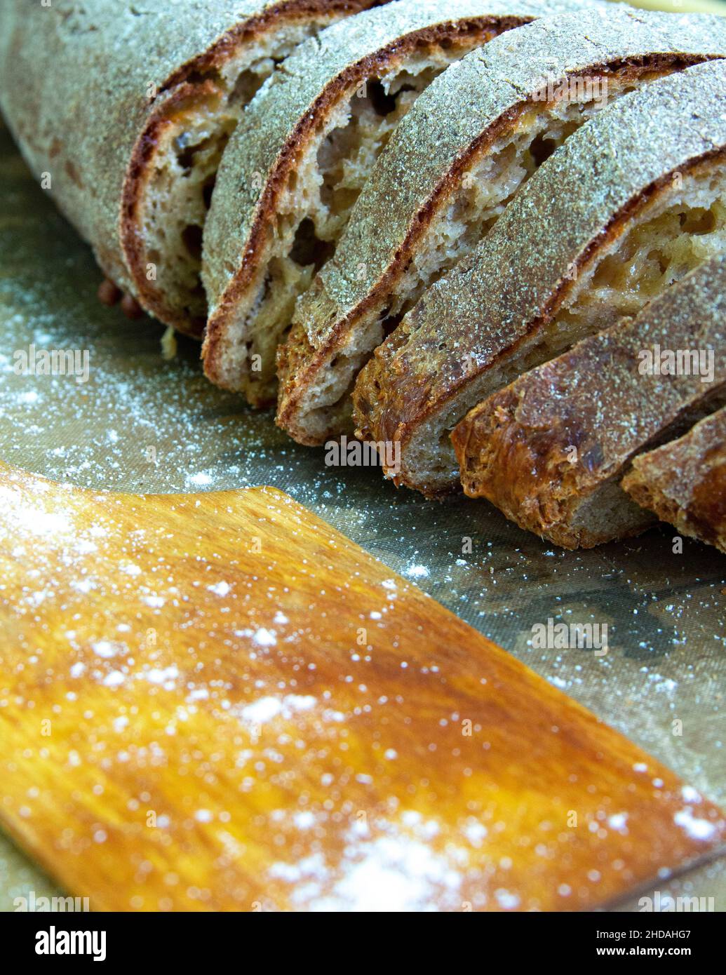 Whole grain sliced bread sprinkled with flour lies on the table Stock ...