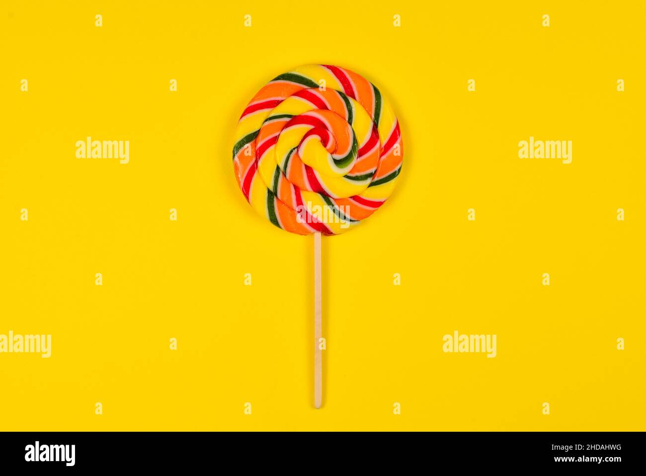 Colorful candy on a yellow background. Lollipop. Top view. Copy space ...
