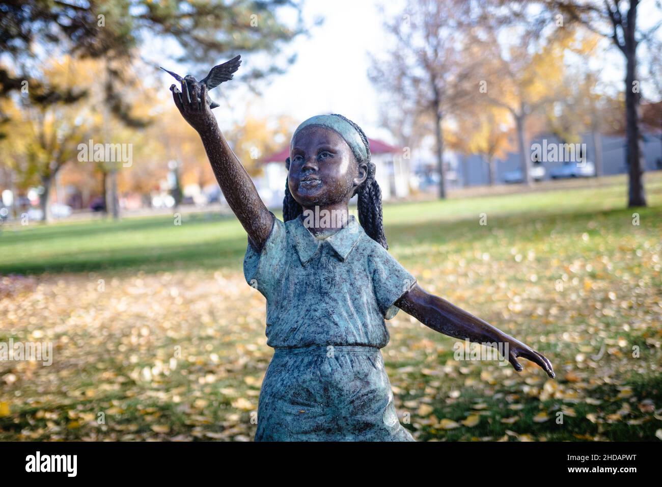 Bronze statue of a girl releasing a bird with her arm into the heavens ...