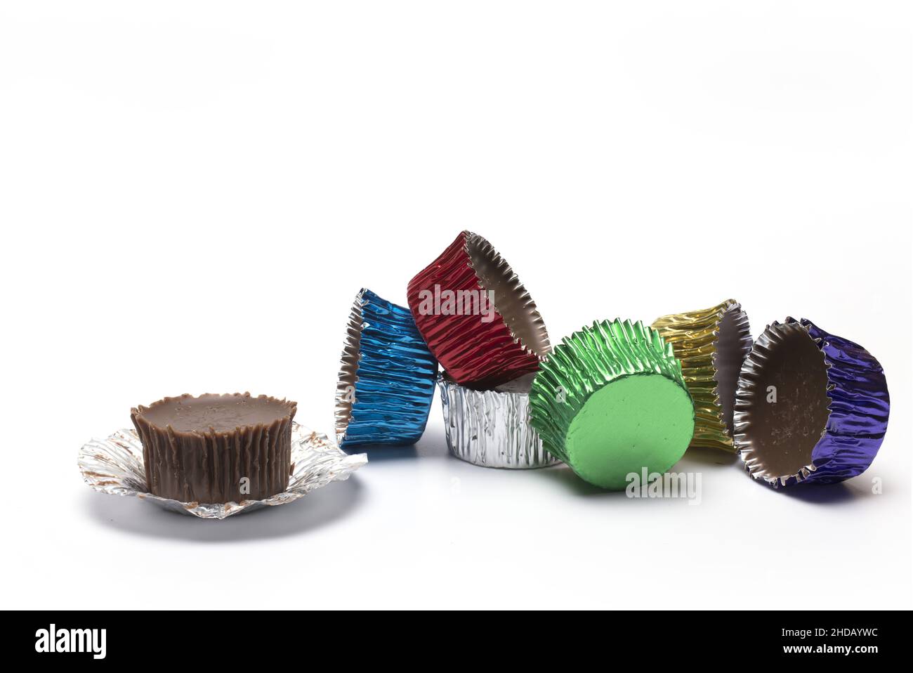 Close up several chocolate candy in different color molds against white ...