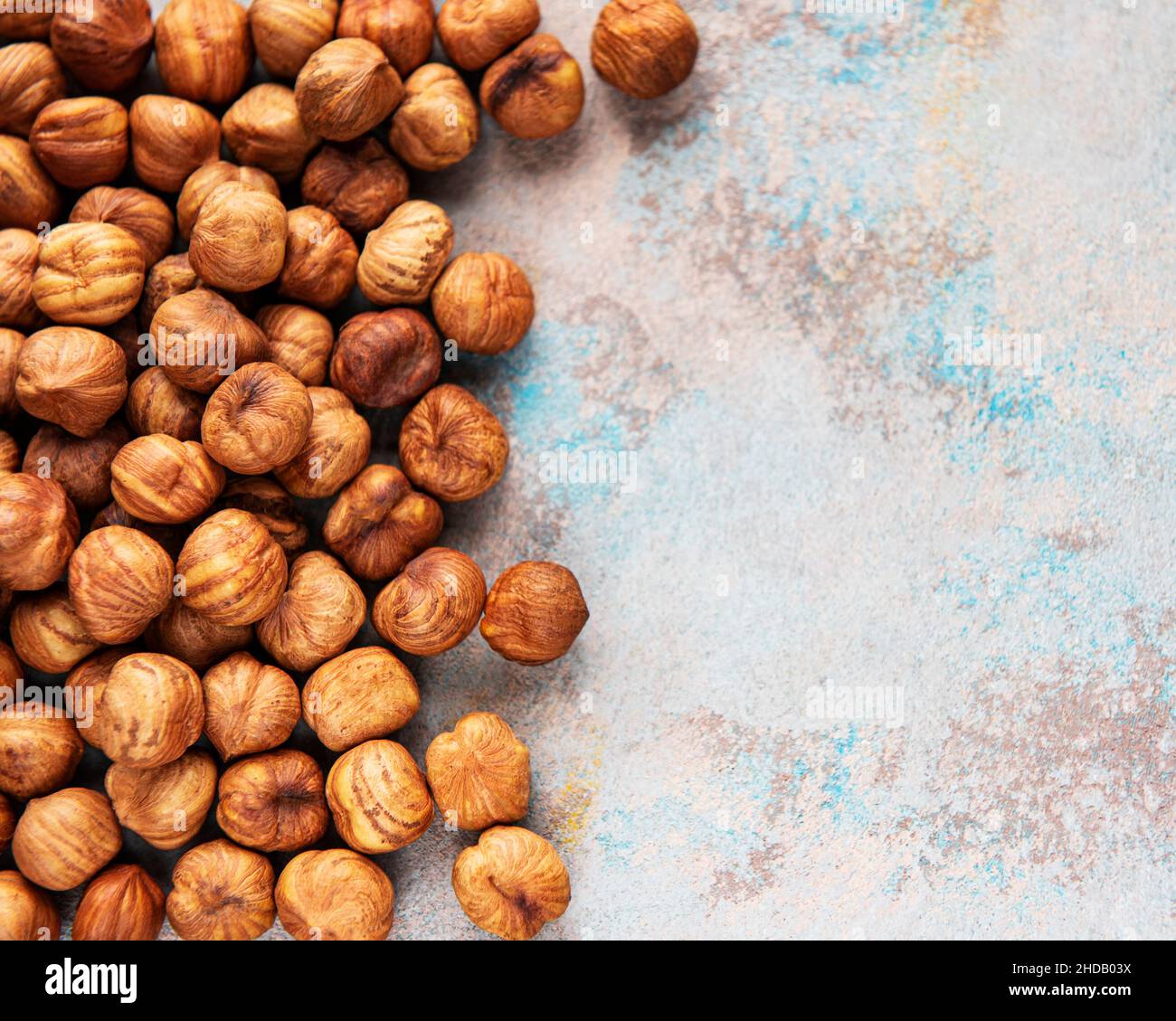 Peeled hazelnuts on a grey concrete background Stock Photo - Alamy