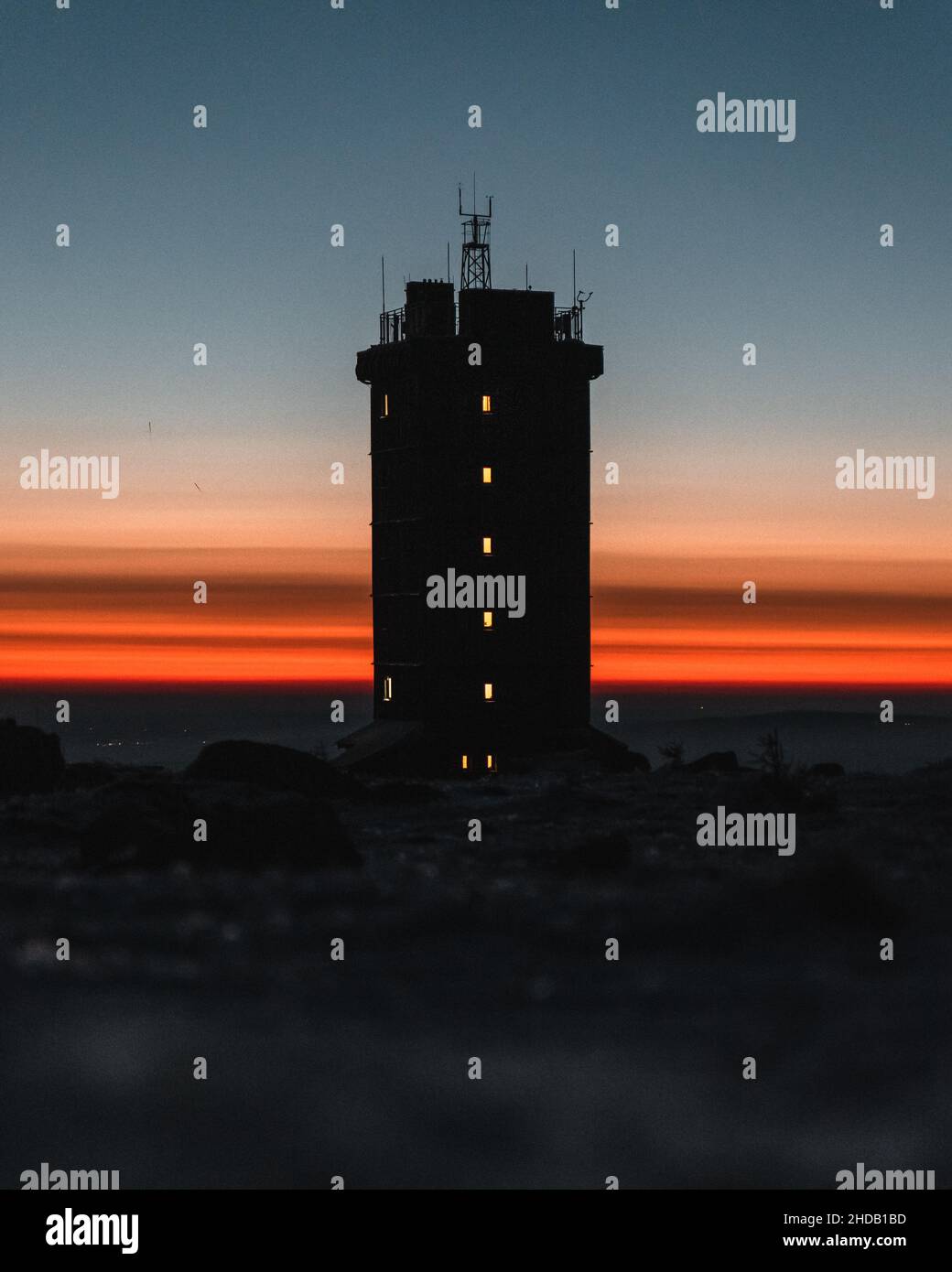 A vertical shot of a silhouette of a building on sunset sky background ...