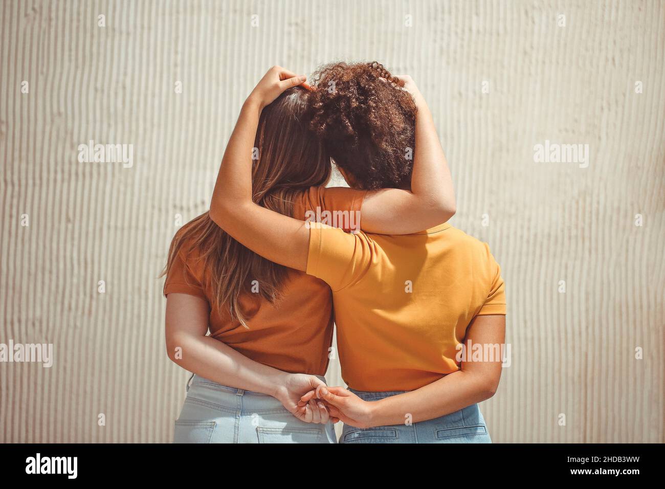Strong female friendship. Rear view two teen girls best friends holding ...