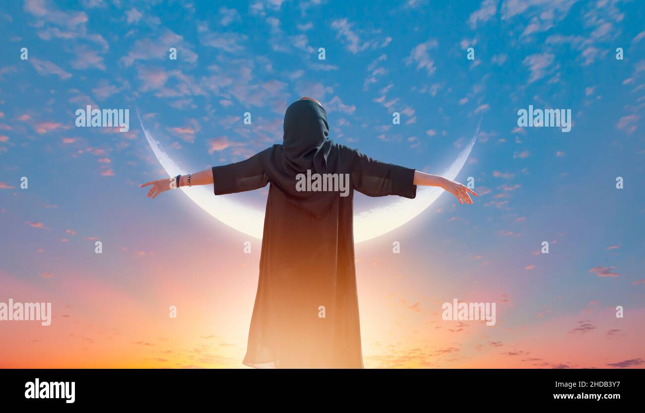 Beautiful girl wearing abaya with arms up happy with crescent moon ...