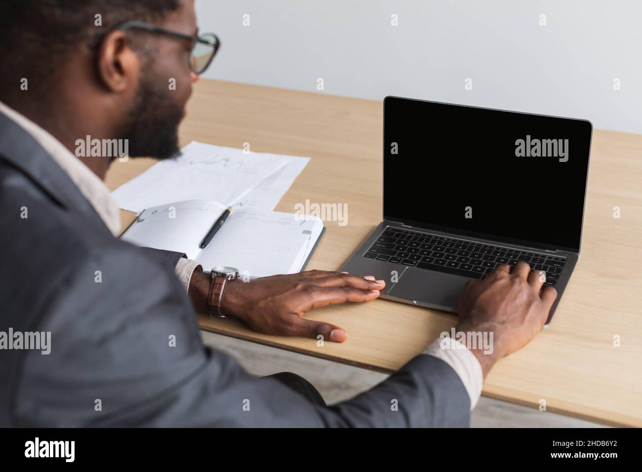 Millennial black entrepreneur working on laptop pc with blank screen at ...
