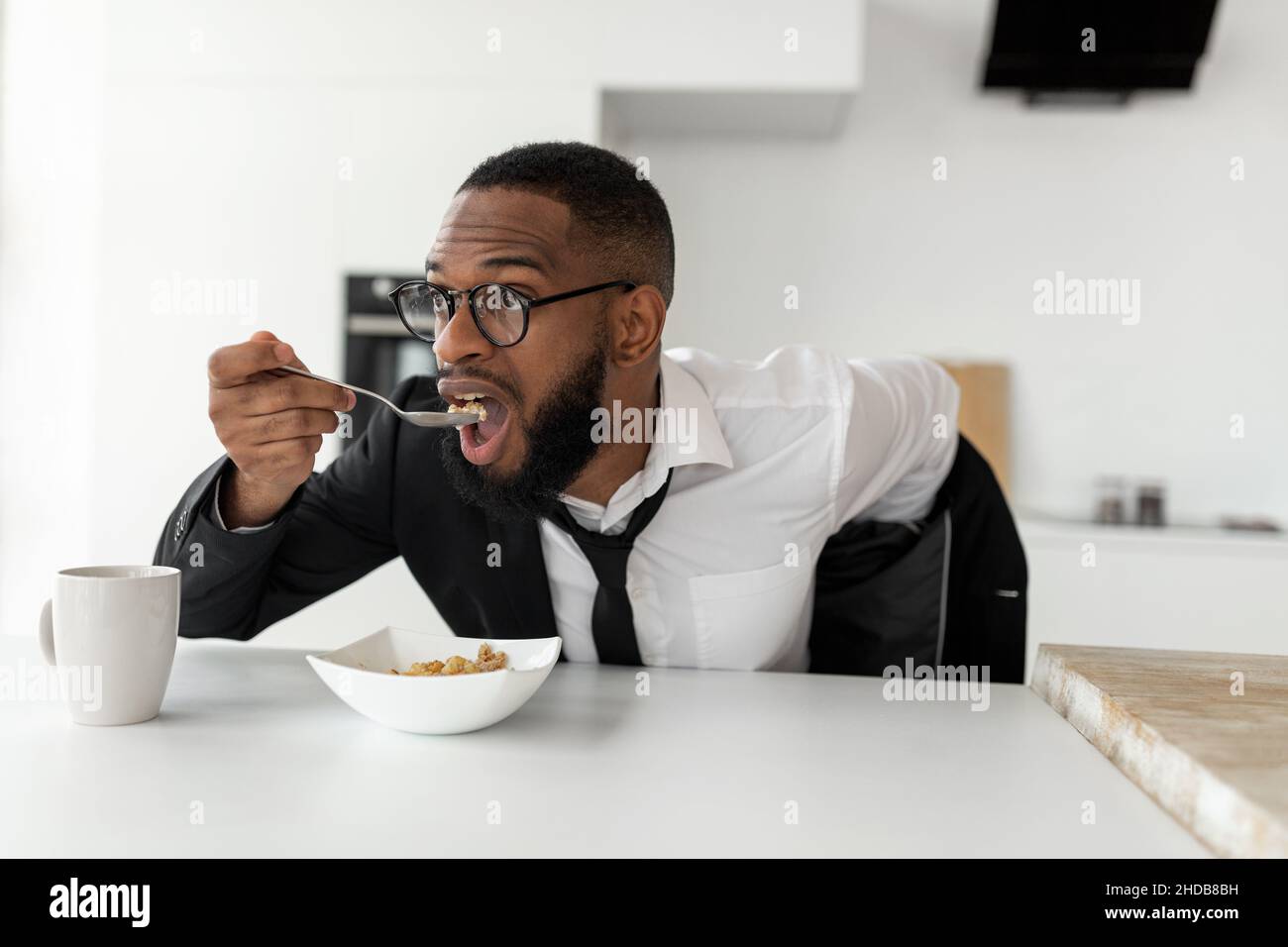Black man rushing to work eating cereal at home Stock Photo - Alamy