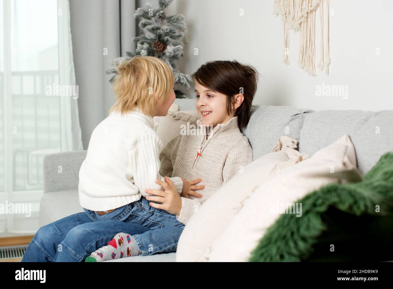 Boy brothers, hugging at home on the sofa, child cuddling in older ...