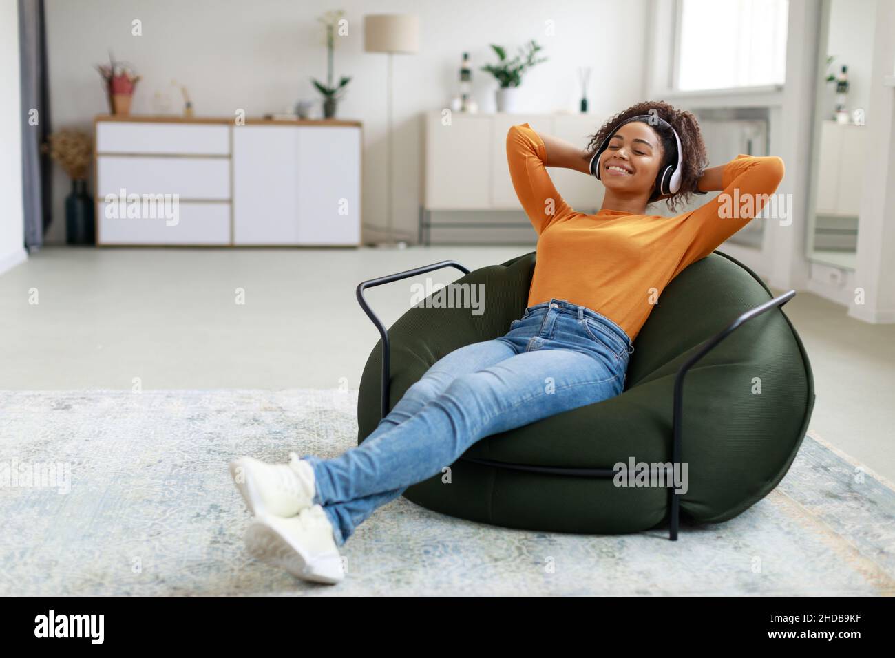 Calm black woman having rest at home on bean bag Stock Photo - Alamy