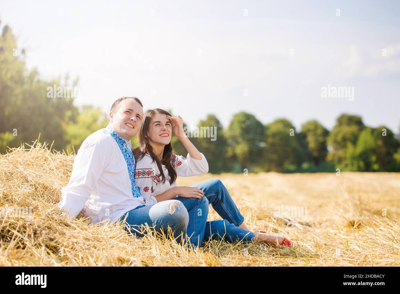 Young couple have a rest in the summer field Stock Photo - Alamy