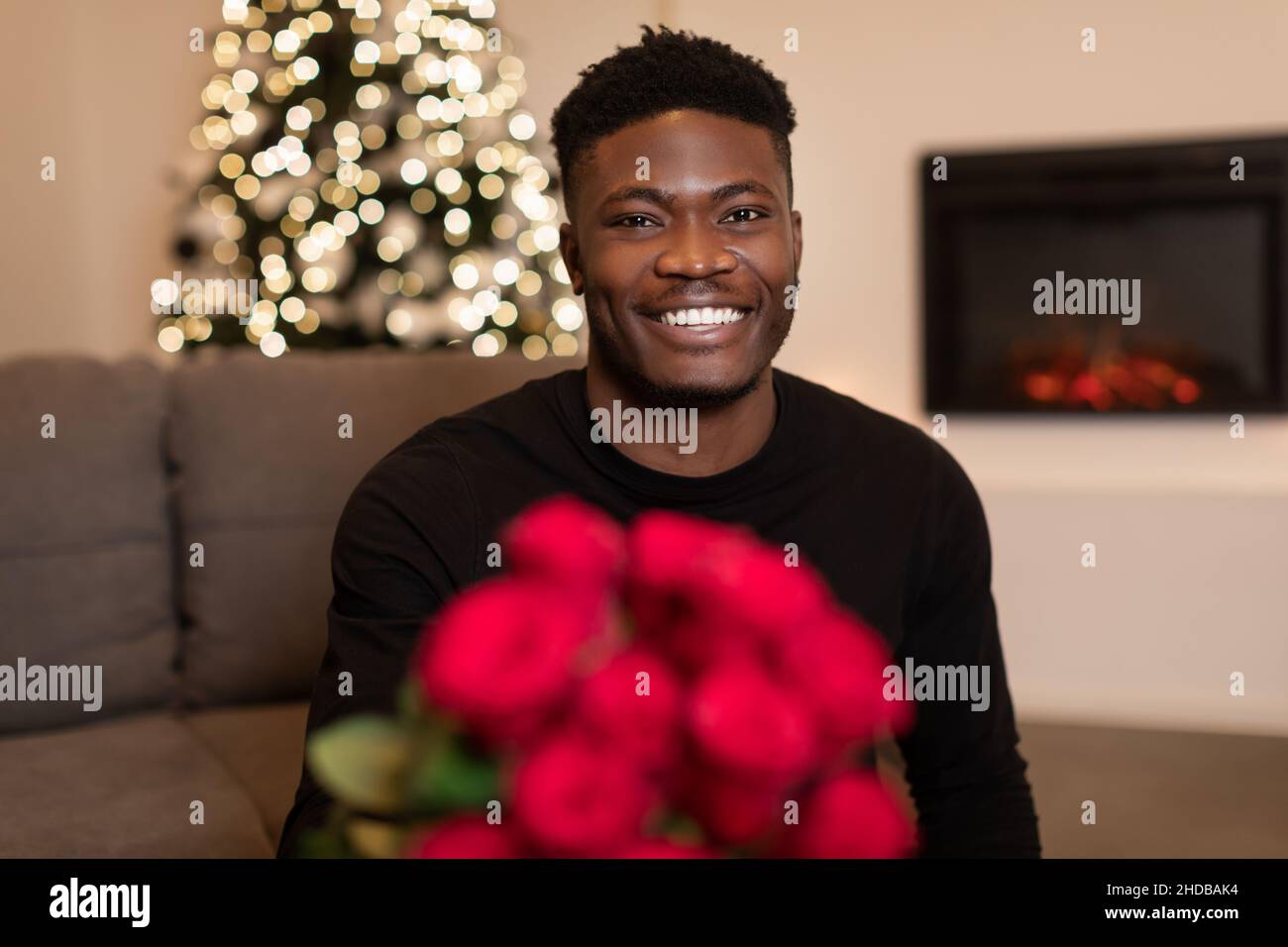 Black Guy Holding Roses Smiling To Camera Celebrating Holiday Indoor ...