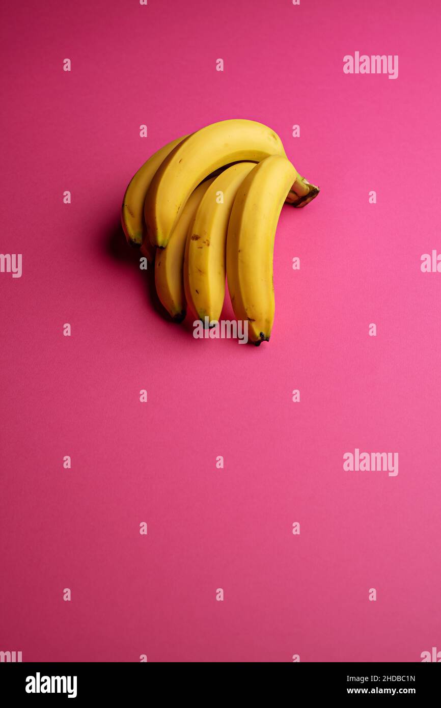 Vertical closeup of a bunch of bananas on pink background Stock Photo ...