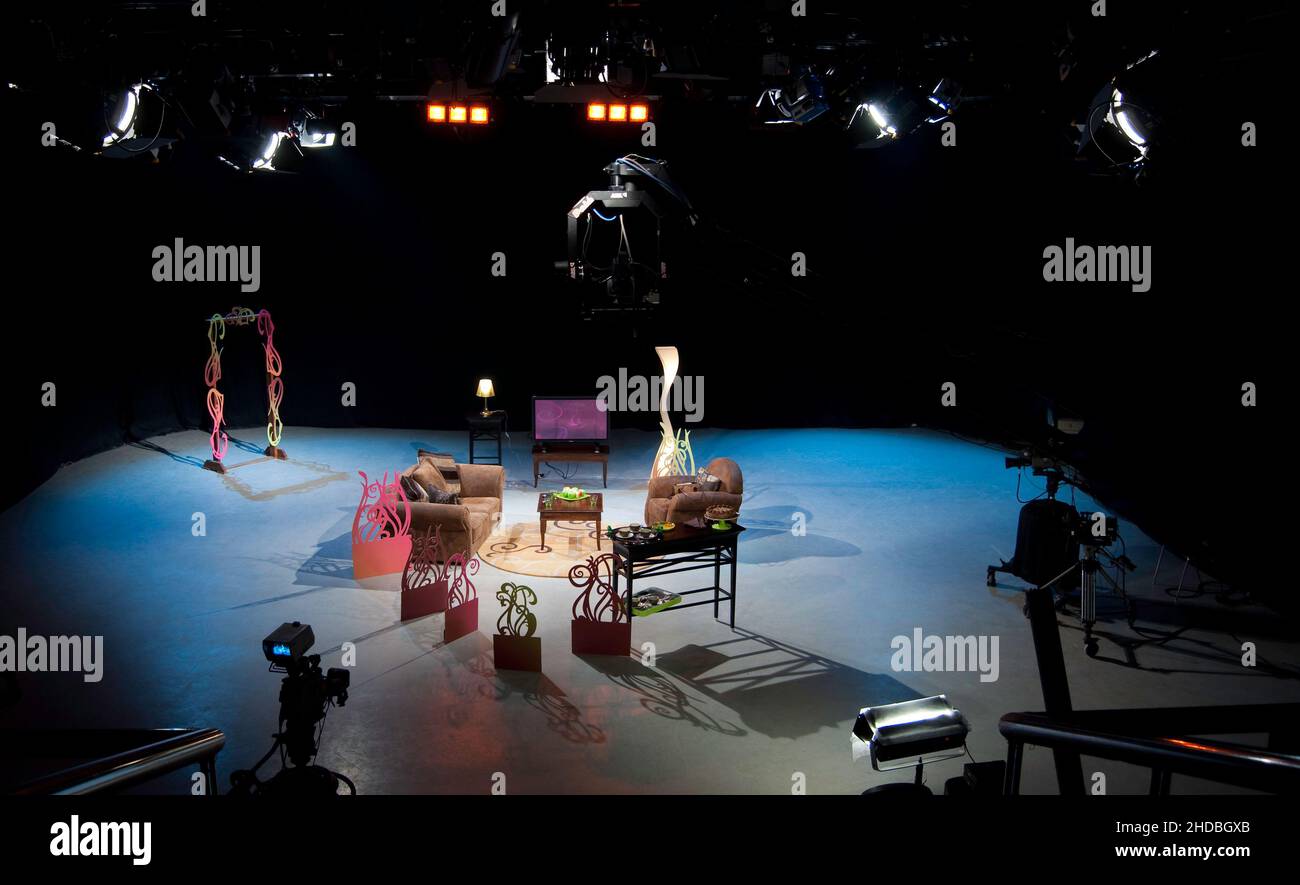 Dark theatre stage with decorations surrounded by cameras and bright ...