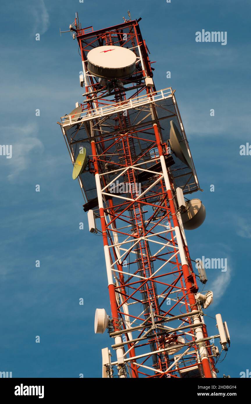 Red and white communication tower over a blue sky Stock Photo - Alamy