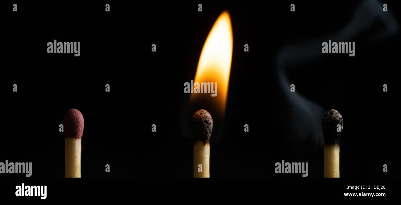 Closeup of three matches of an extinguished match next to a burning one ...