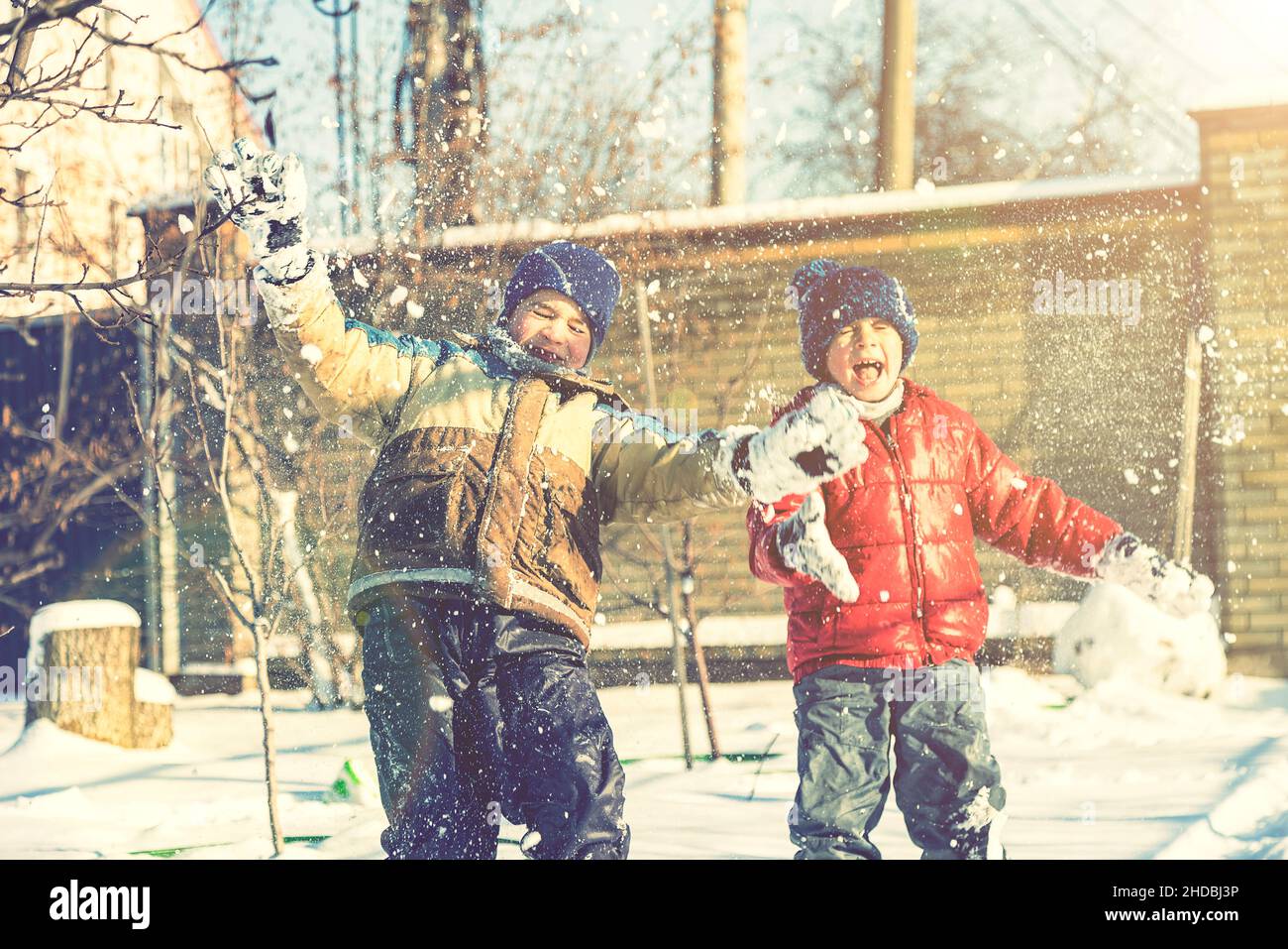 Two boys play with snow. Happy childhood. Brothers on a walk. two kids ...