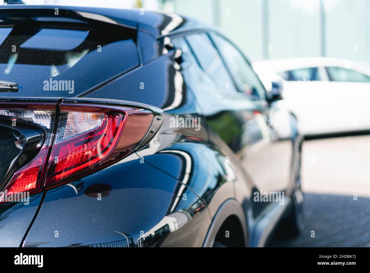 Close-up shot of the tail light of a blue modern car under the sunlight ...