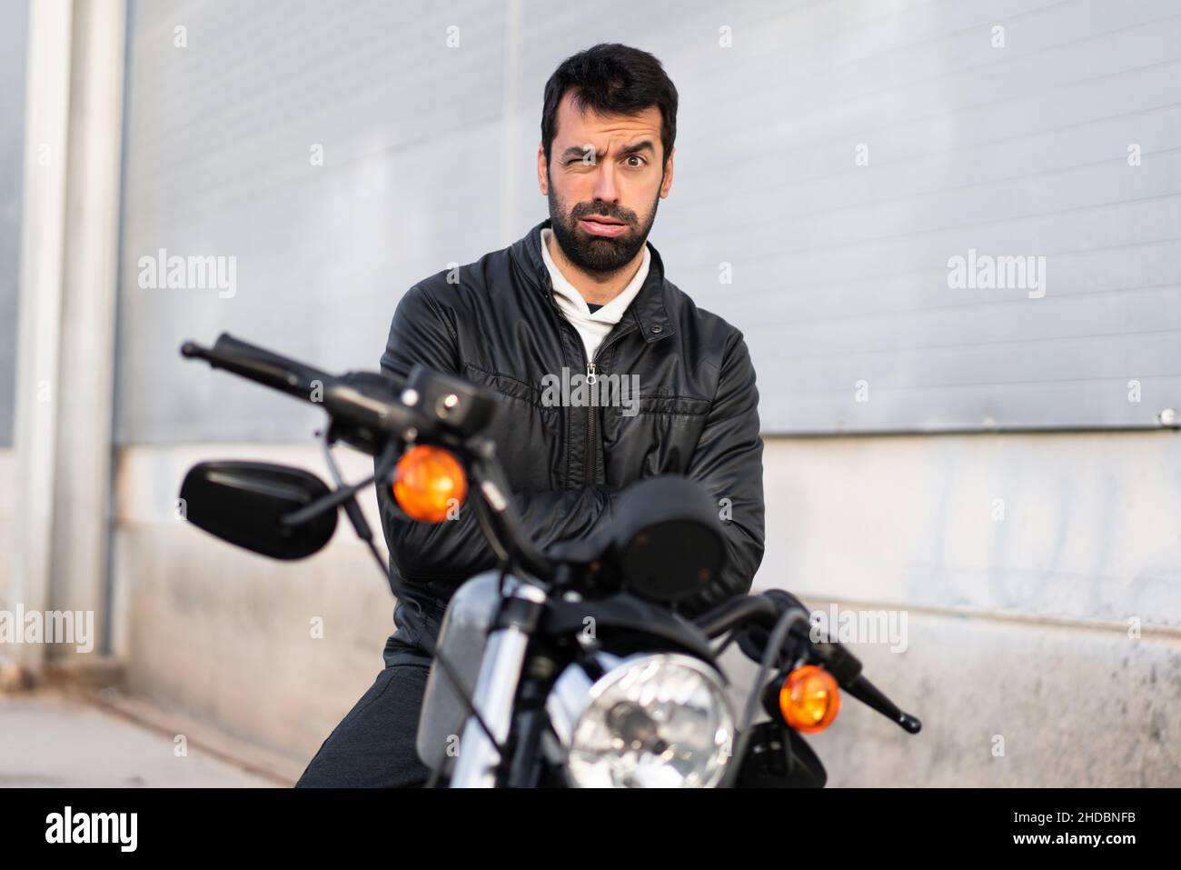 Sad young man on a motorbike Stock Photo - Alamy