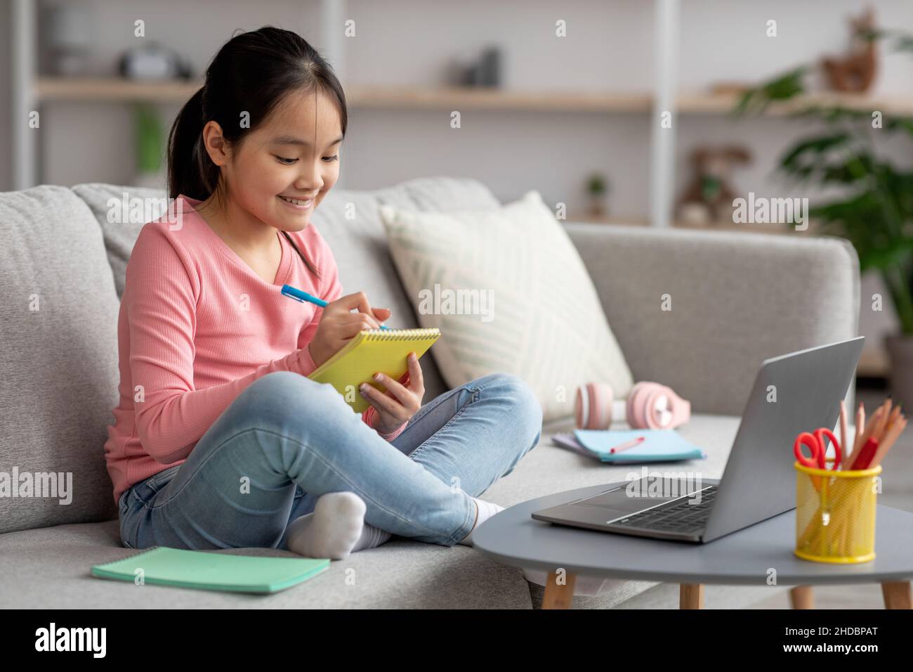 Smart asian kid studying at home, taking notes, using laptop Stock ...