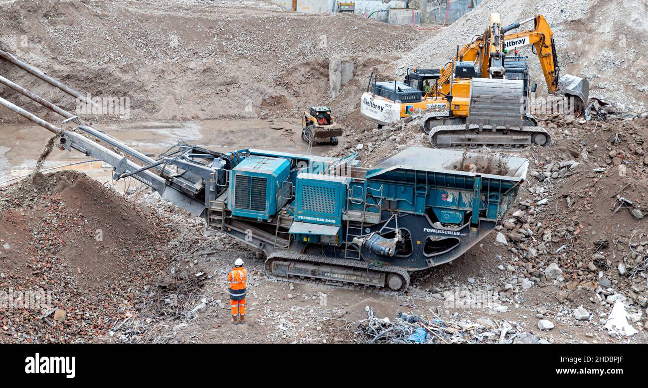 Construction worker on a site, digging with machines Stock Photo - Alamy