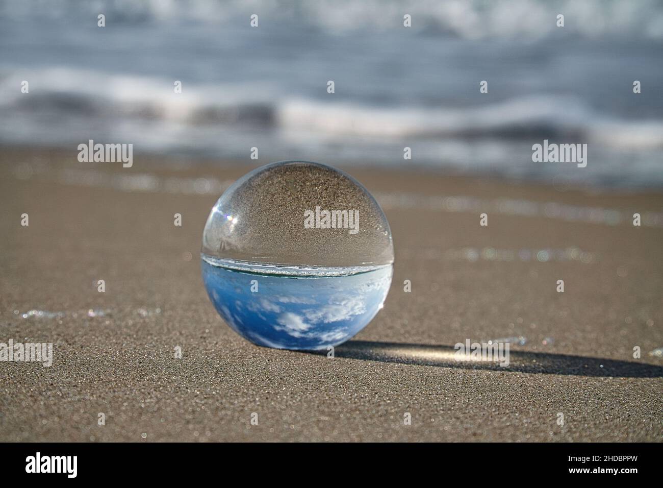 glass sphere on the beach of the baltic sea. detailed close up of the ...