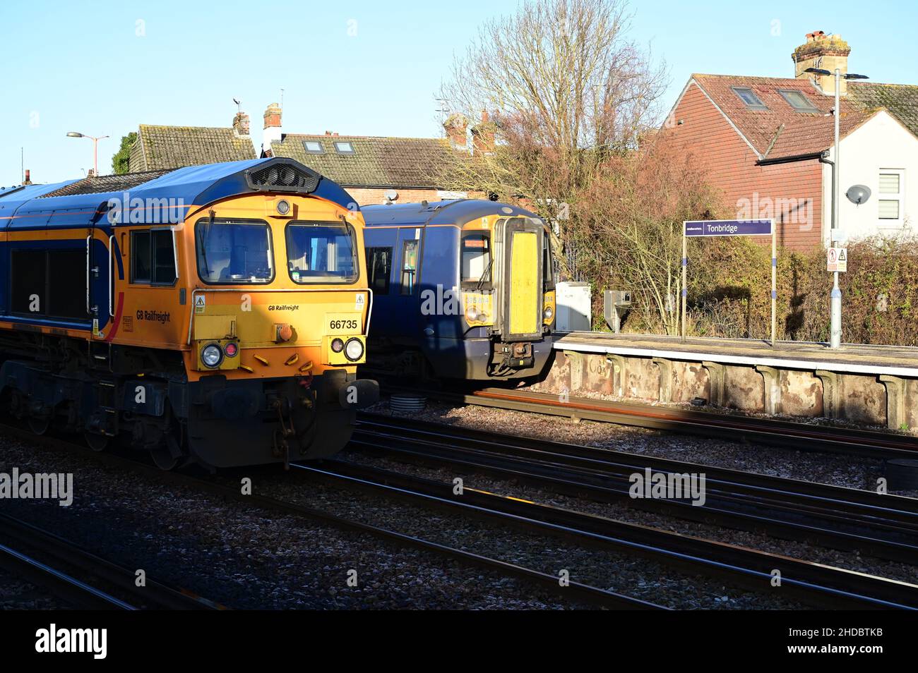 A diesel locomotive and a passenger train arriving at Tonbridge station ...