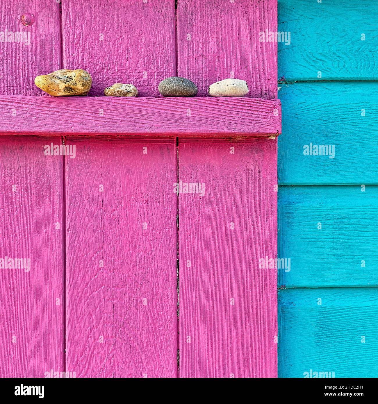 Four discarded stones on a beam, detail of a colourful wooden facade ...