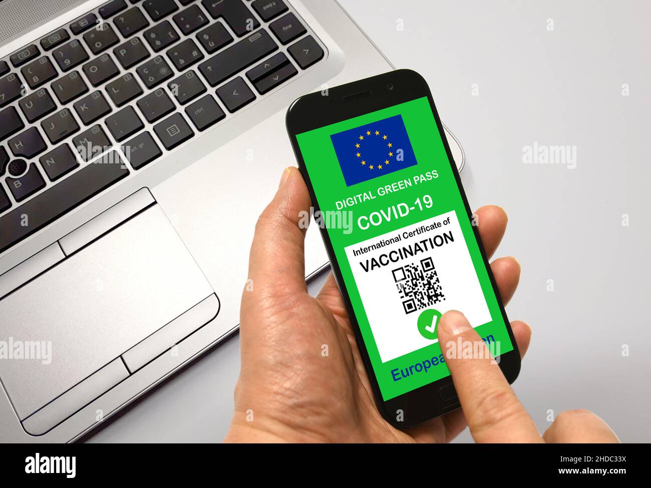 a man holds a smartphone with the European Union digital green pass for ...