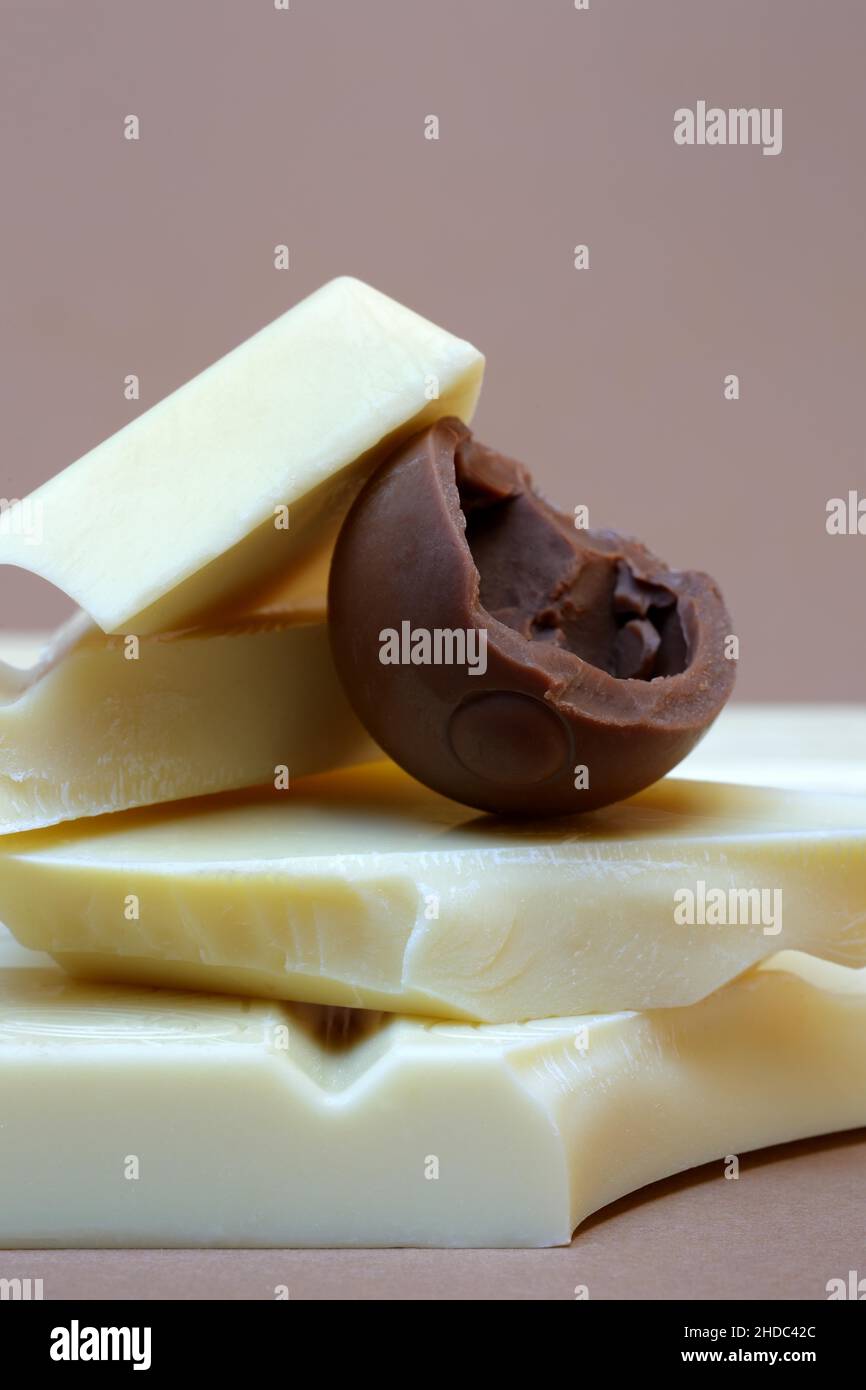 White chocolate pieces and milk chocolate praline, bitten into Stock ...