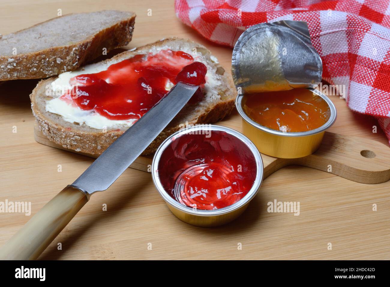 Slice of bread with jam and jam in portion pack, jam Stock Photo - Alamy