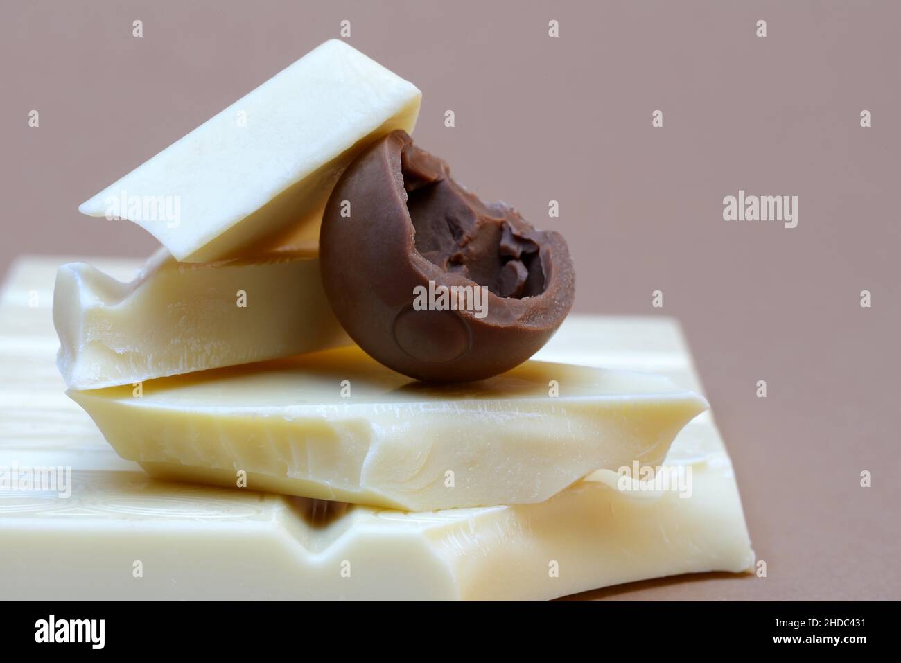 White chocolate pieces and milk chocolate praline, bitten into Stock ...