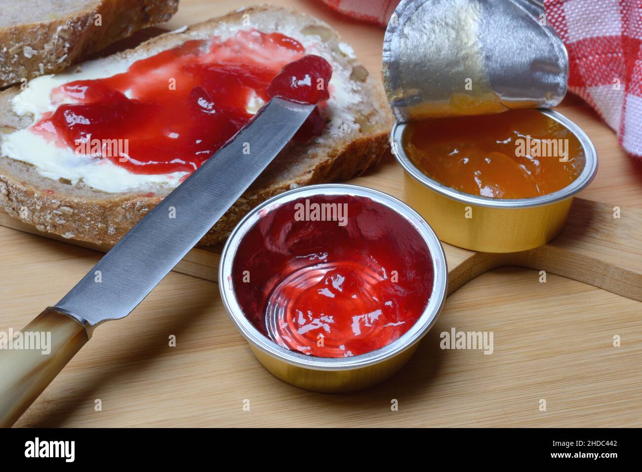 Slice of bread with jam and jam in portion pack, jam Stock Photo - Alamy