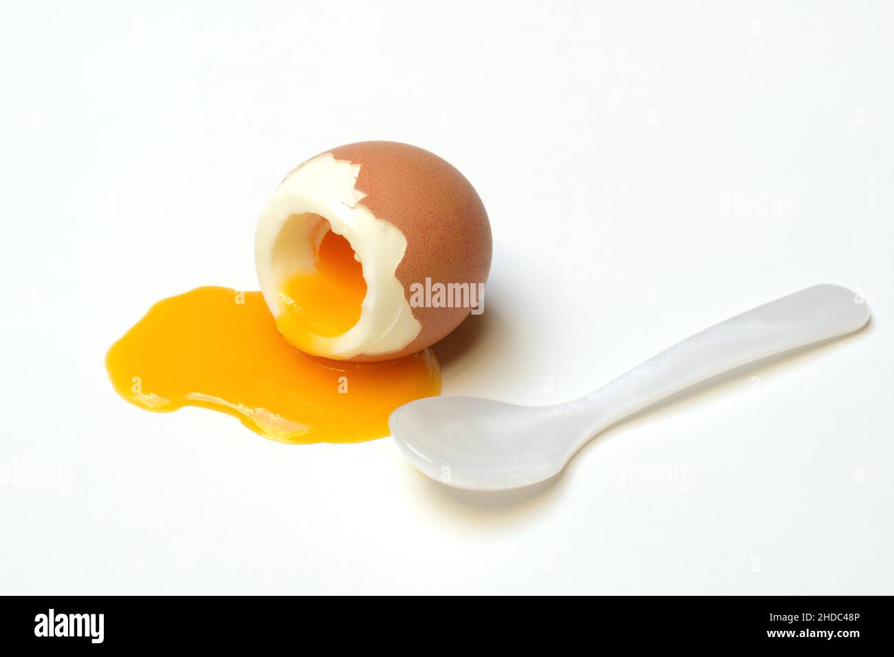 Spilled soft-boiled breakfast egg with spoon Stock Photo - Alamy