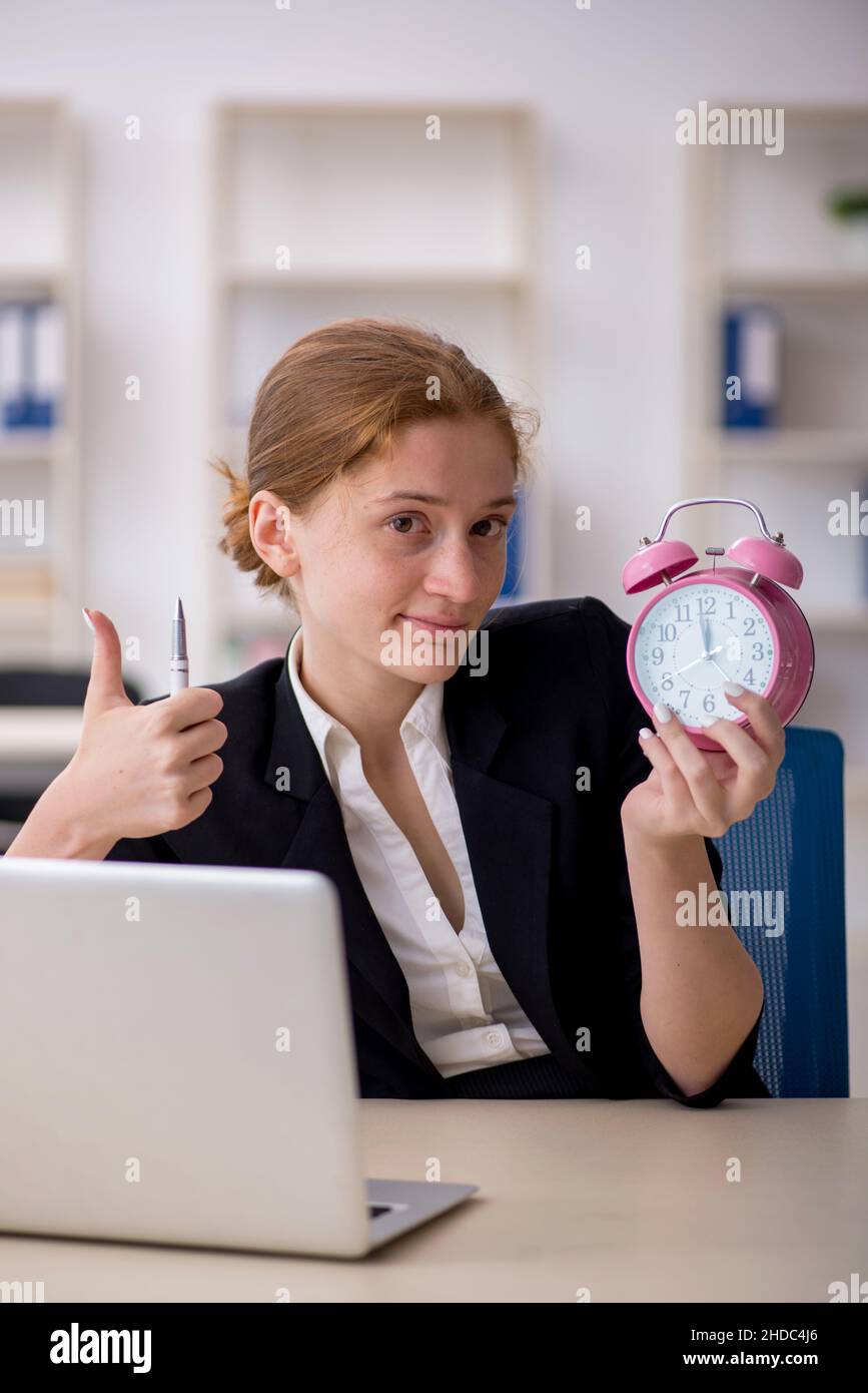 Female employee in time management concept Stock Photo - Alamy