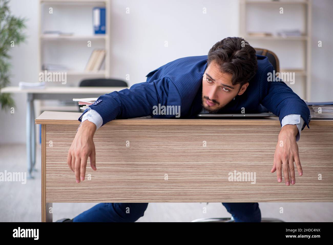 Young businessman employee extremely tired at workplace Stock Photo - Alamy