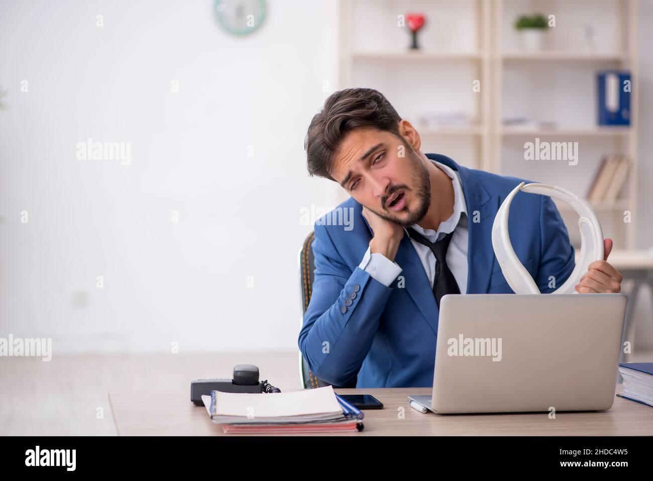 Young neck injured businessman employee at workplace Stock Photo - Alamy