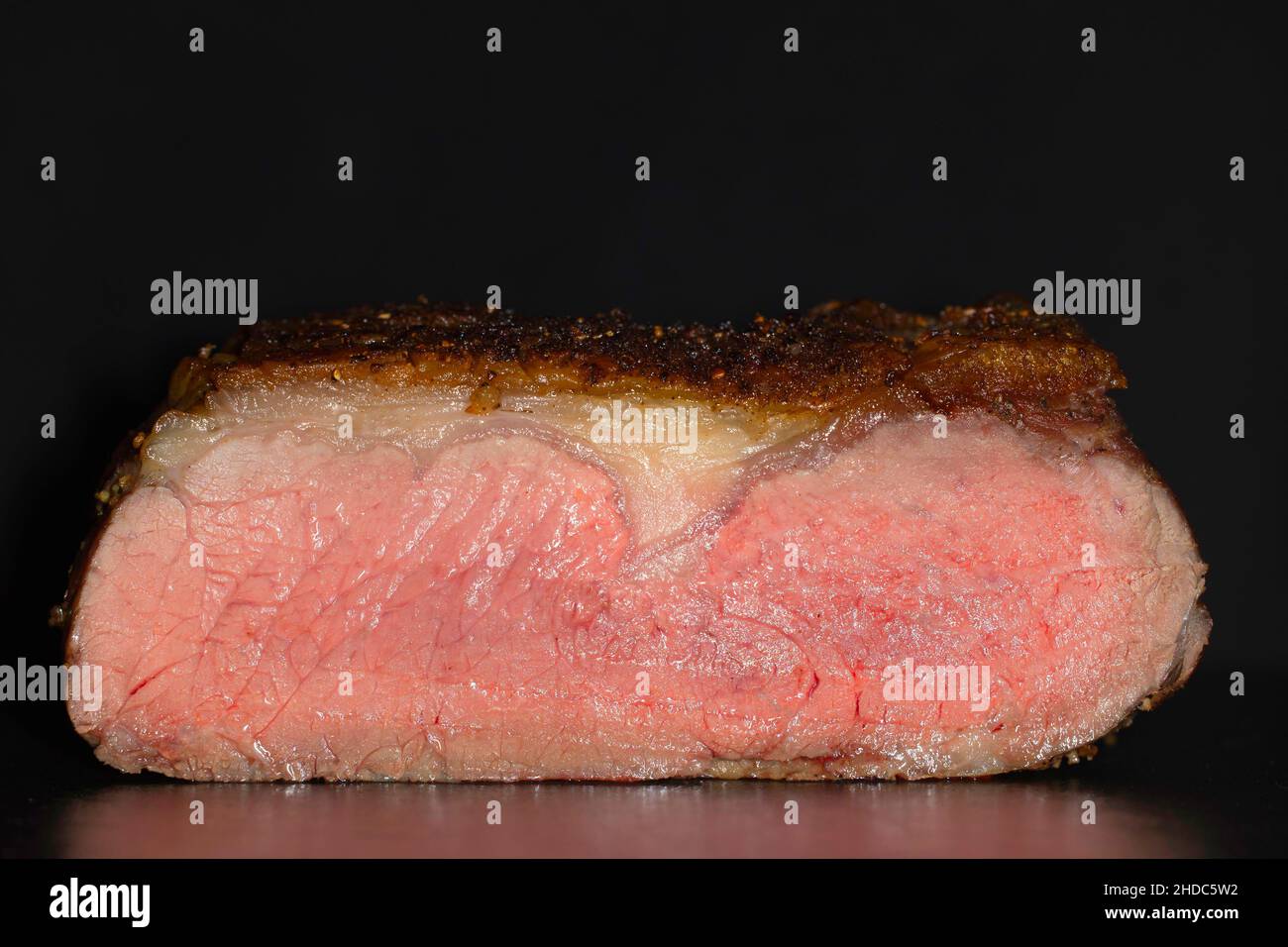 Freshly cut pink roasted prime rib, studio photography with black ...