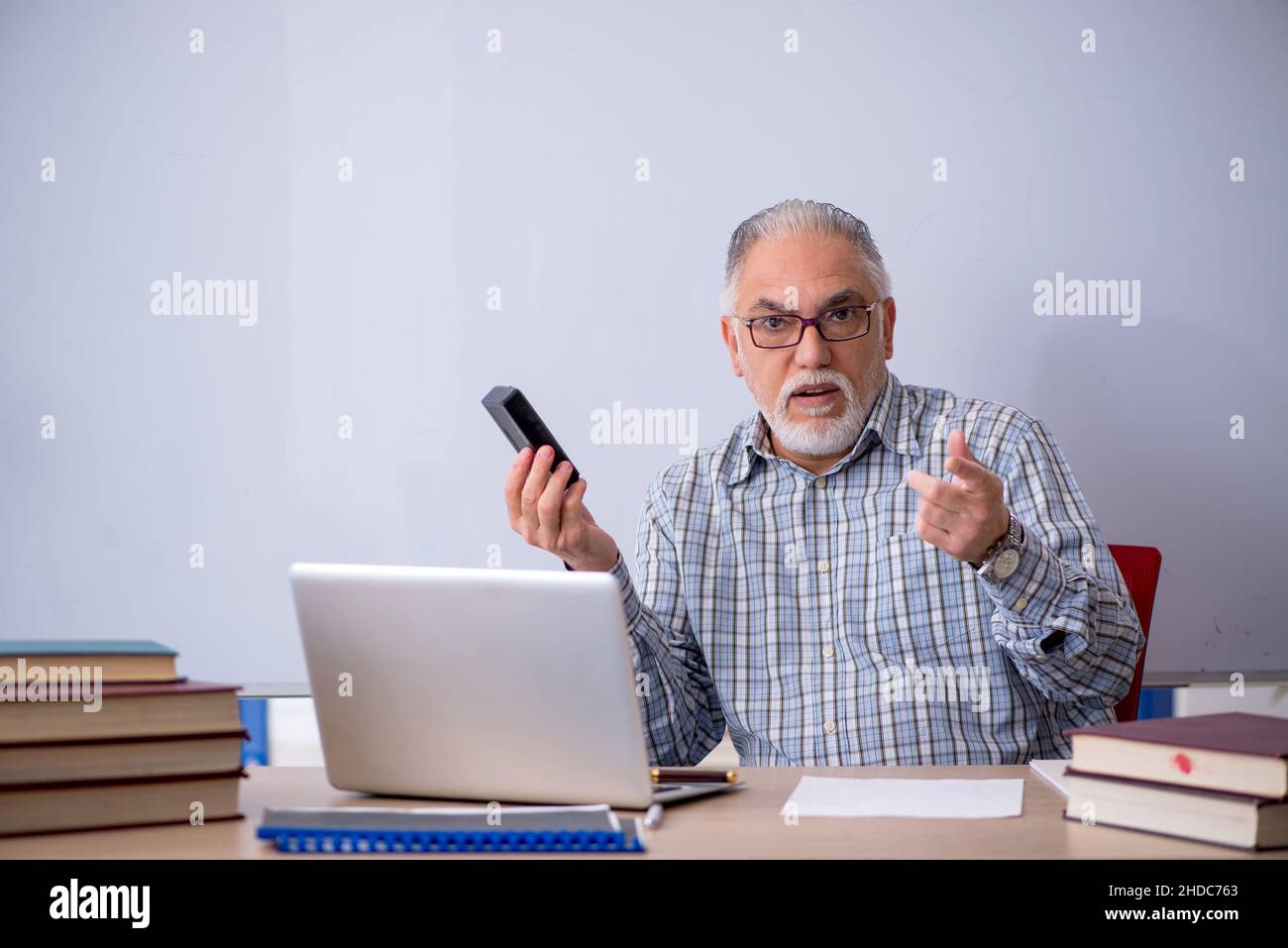 Aged male teacher in the classroom Stock Photo - Alamy