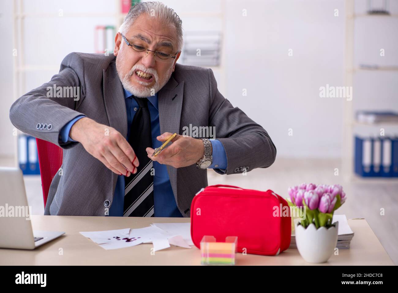 Old businessman employee cutting his hand at workplace Stock Photo - Alamy
