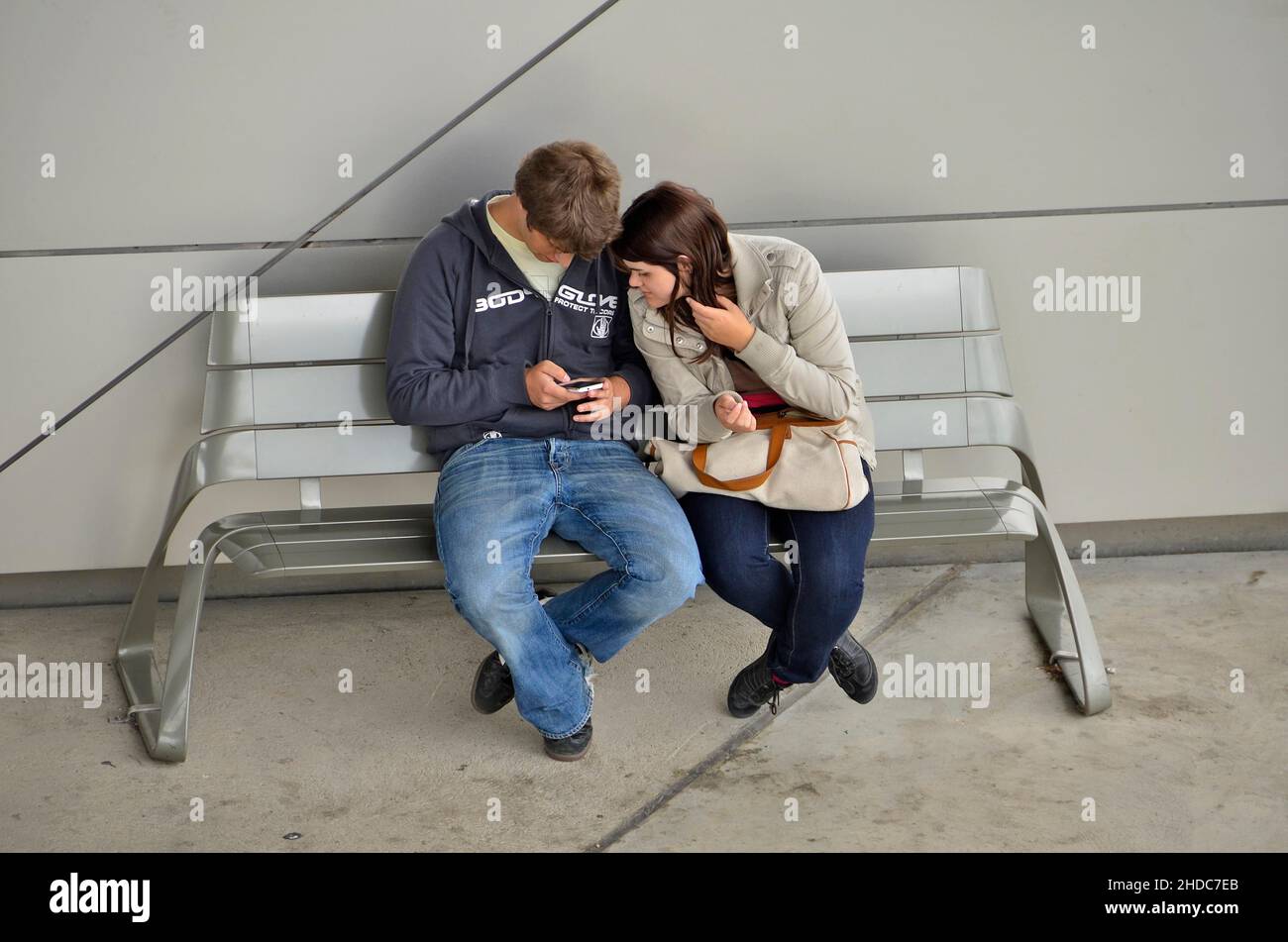 Couple smartphone sitting on bench hi-res stock photography and images ...