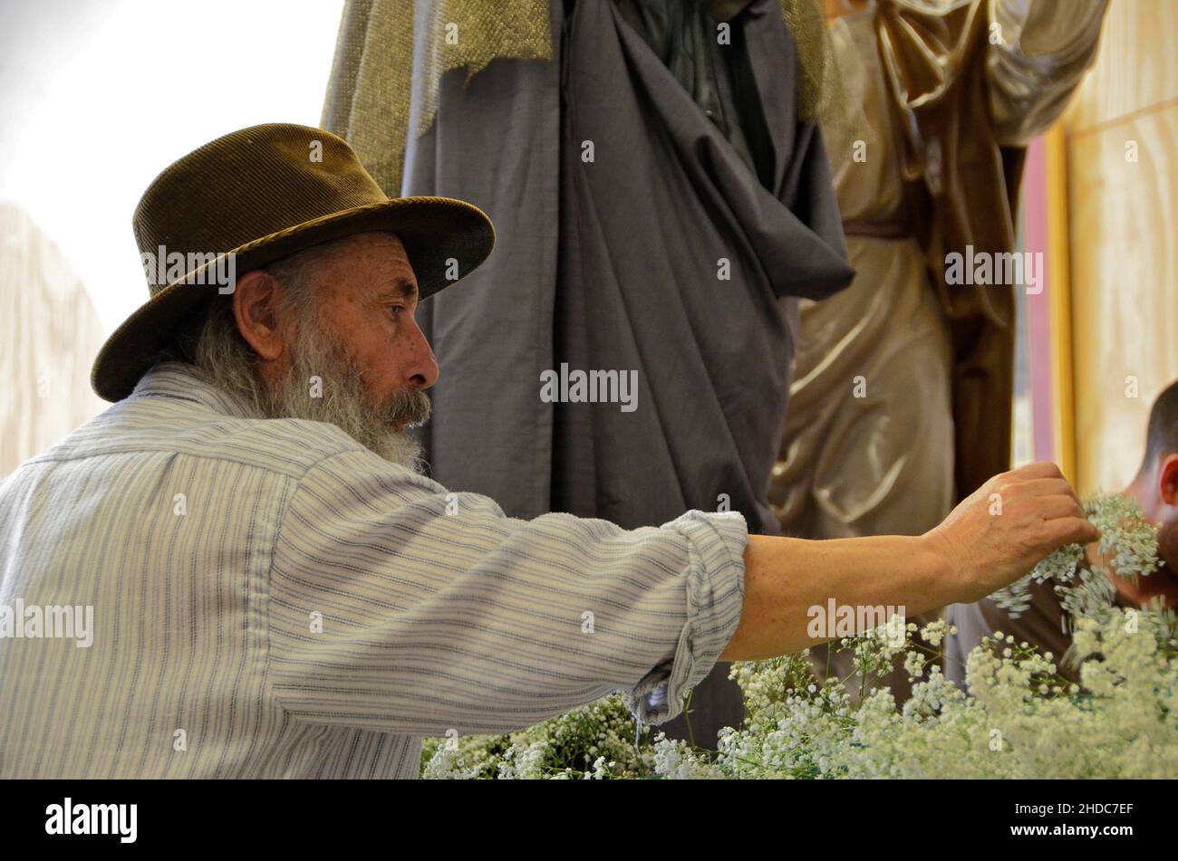 Old man with hat decorates altar in church for Easter, Andalusia, Spain ...