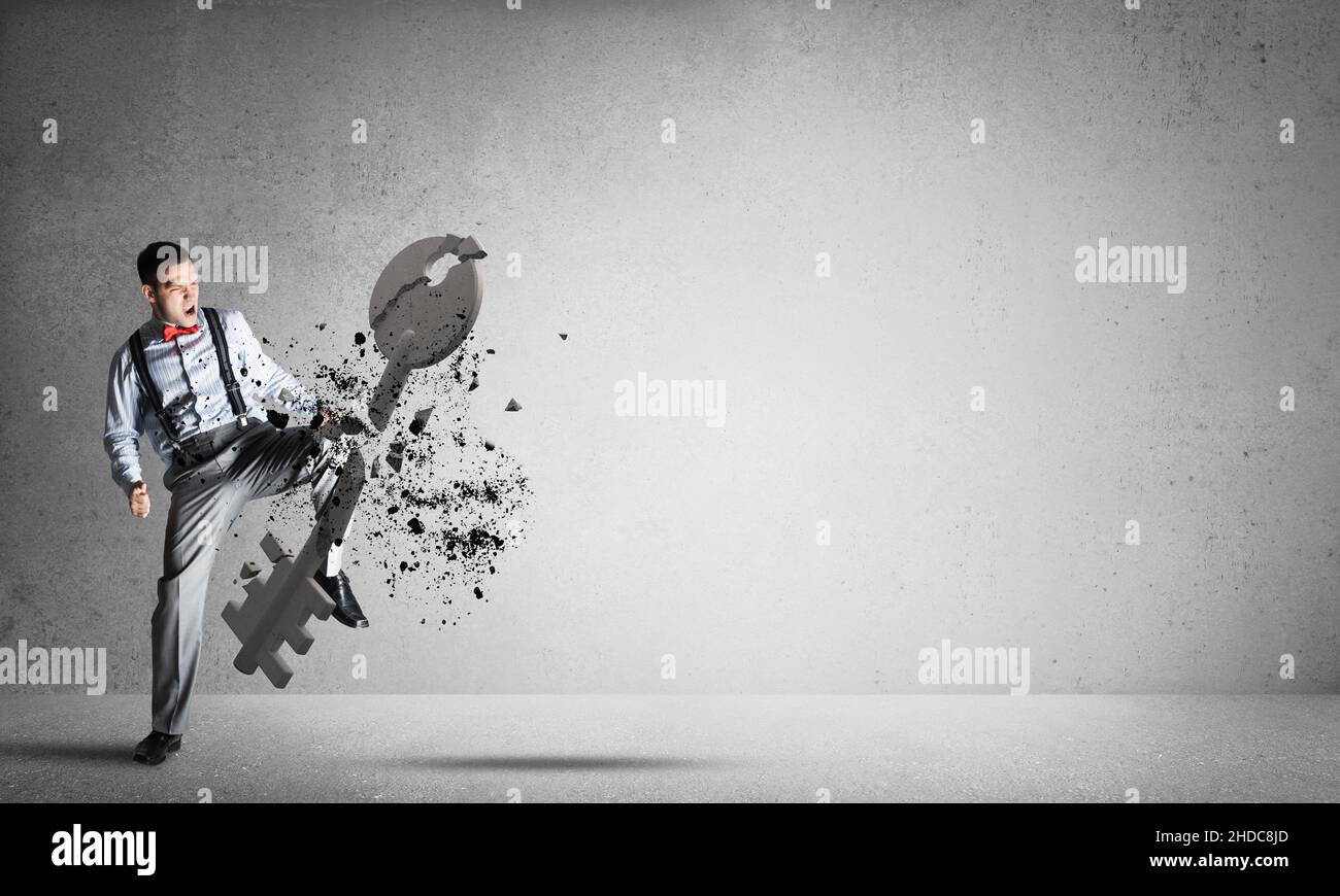 Breaking through access concept with man in room crashing concrete key ...