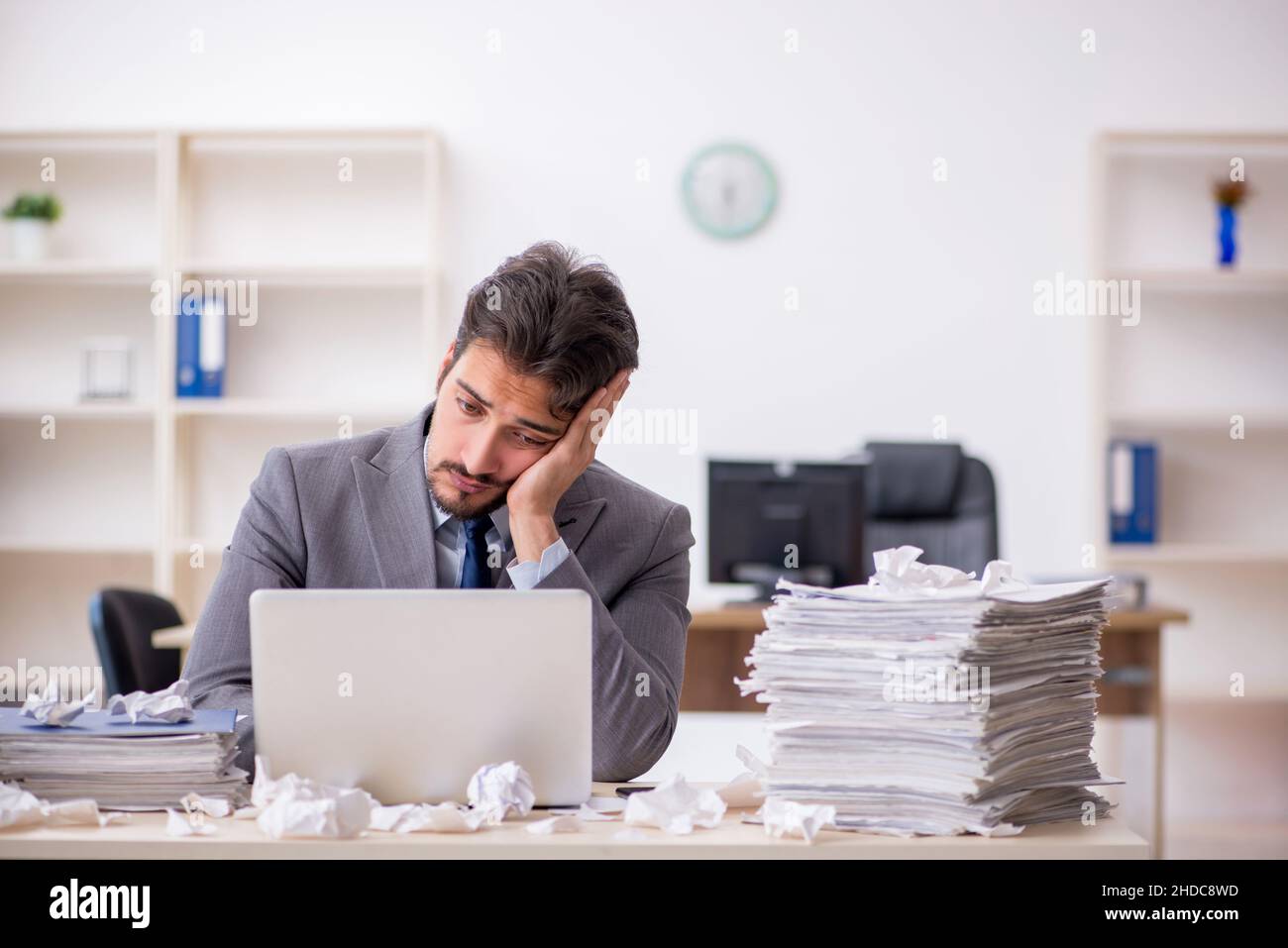 Young employee and too much work in the office Stock Photo - Alamy
