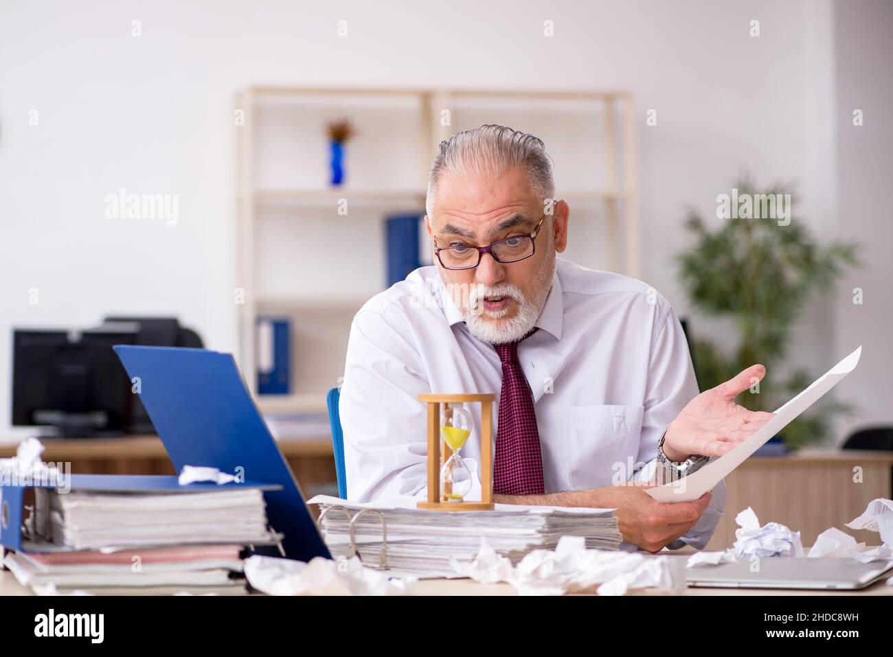 Old employee in time management concept Stock Photo - Alamy