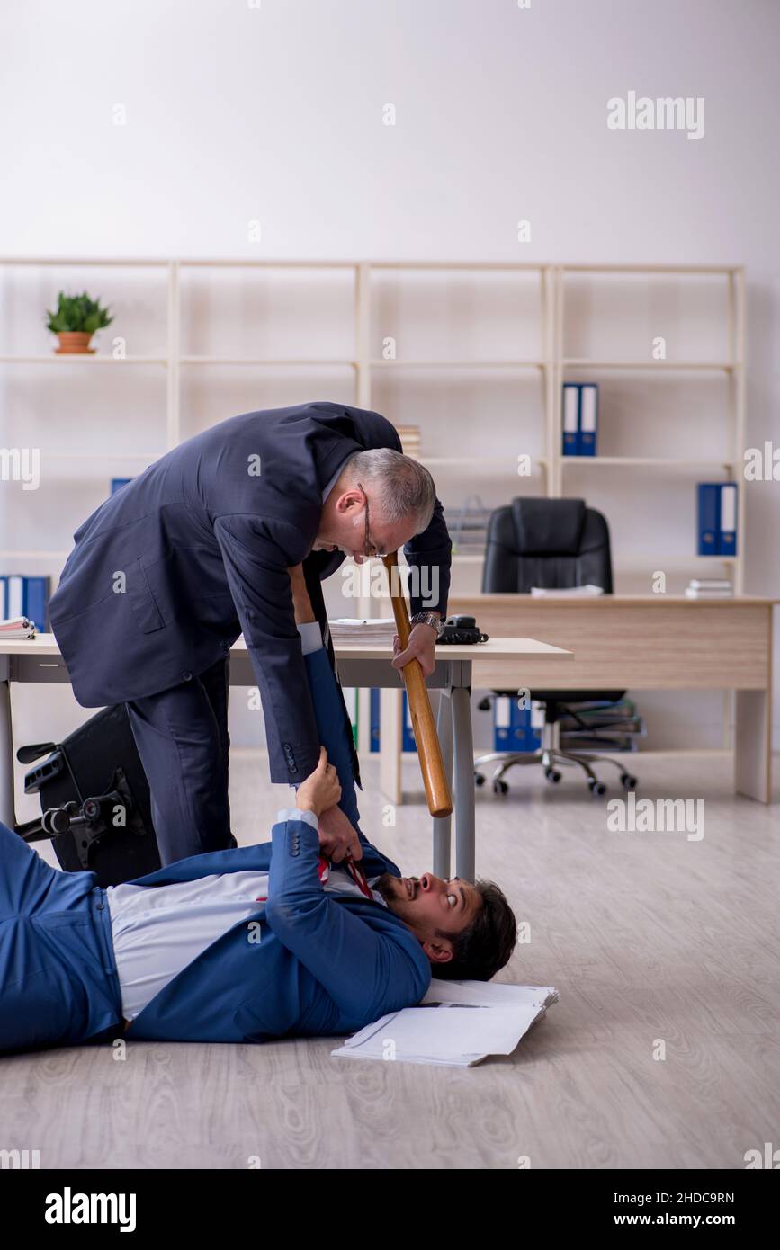 Old boss and young employee in bullying concept Stock Photo - Alamy