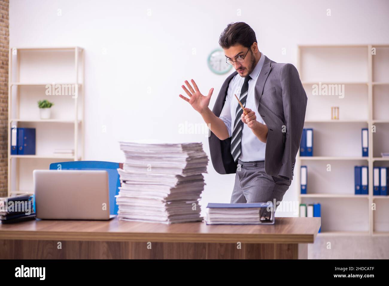 Funny young employee magician and too much work in the office Stock ...