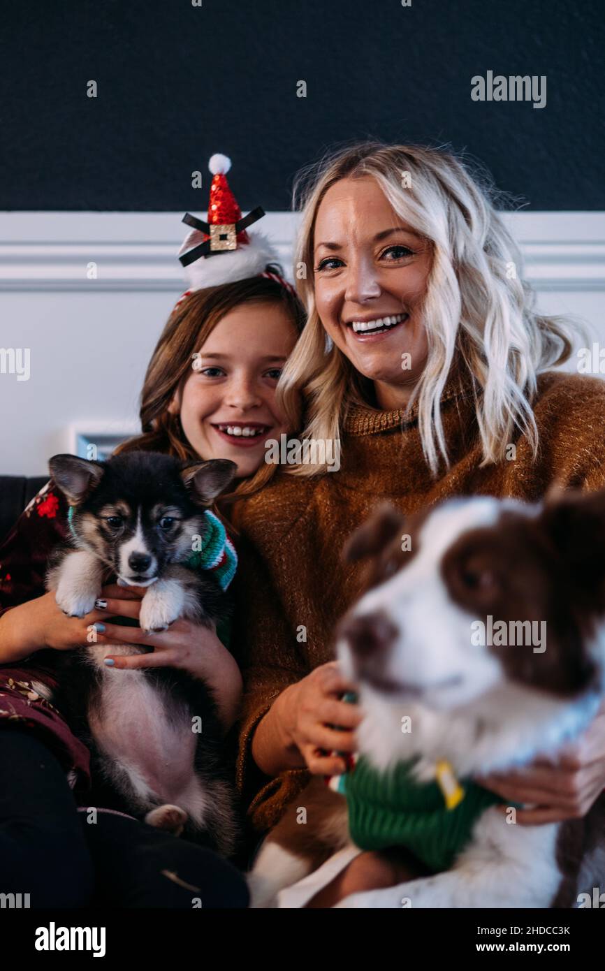 Mom and daughter sitting on couch with dogs Stock Photo - Alamy