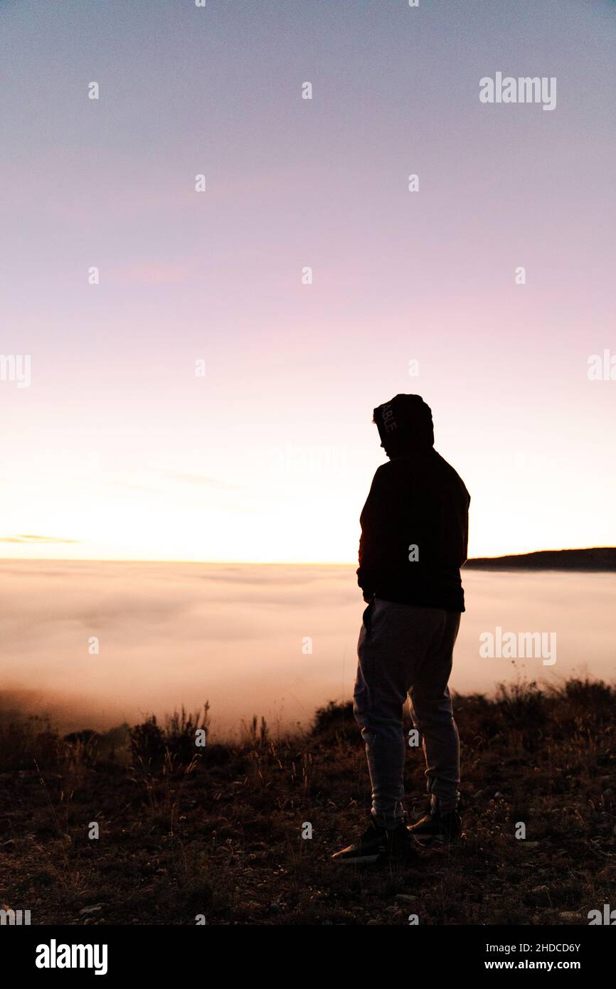 Silhouette of a boy from behind contemplating a sunset Stock Photo - Alamy