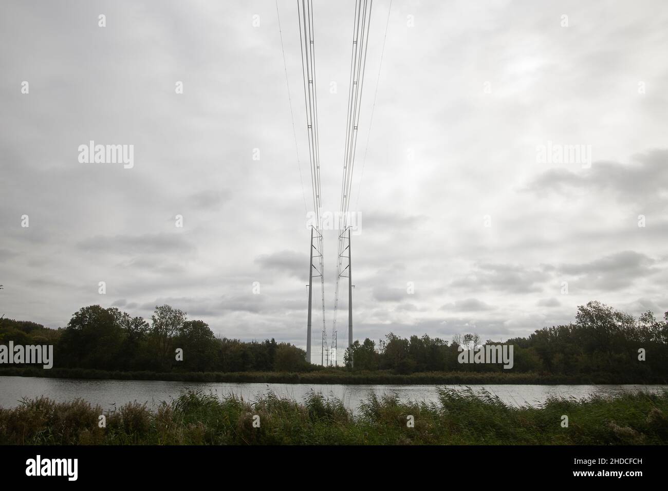 Modern power lines across the canal Stock Photo - Alamy